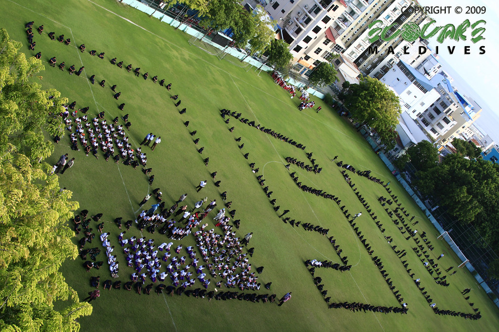 Aerial view of about 4,700 Maldivian students forming the number 350 on a school field for climate action