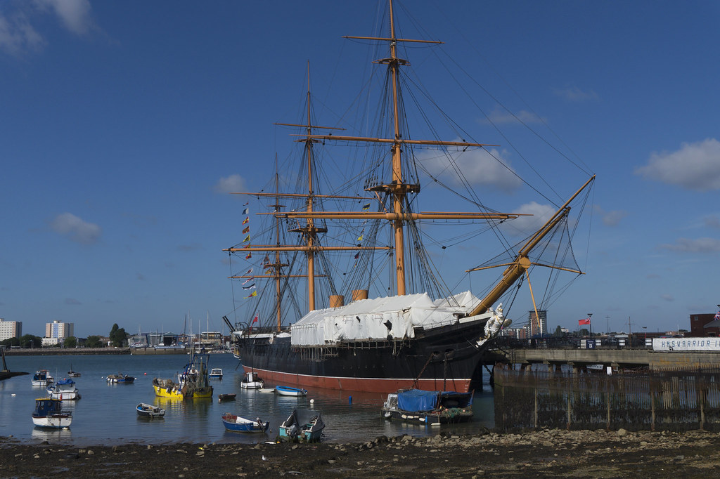 All at Sea: Historic Tall Ship in Calm Harbor beneath a Clear Blue Sky