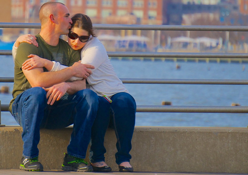 Couple Embracing on a Hudson River Waterfront Promenade with Manhattan Skyline in the Background