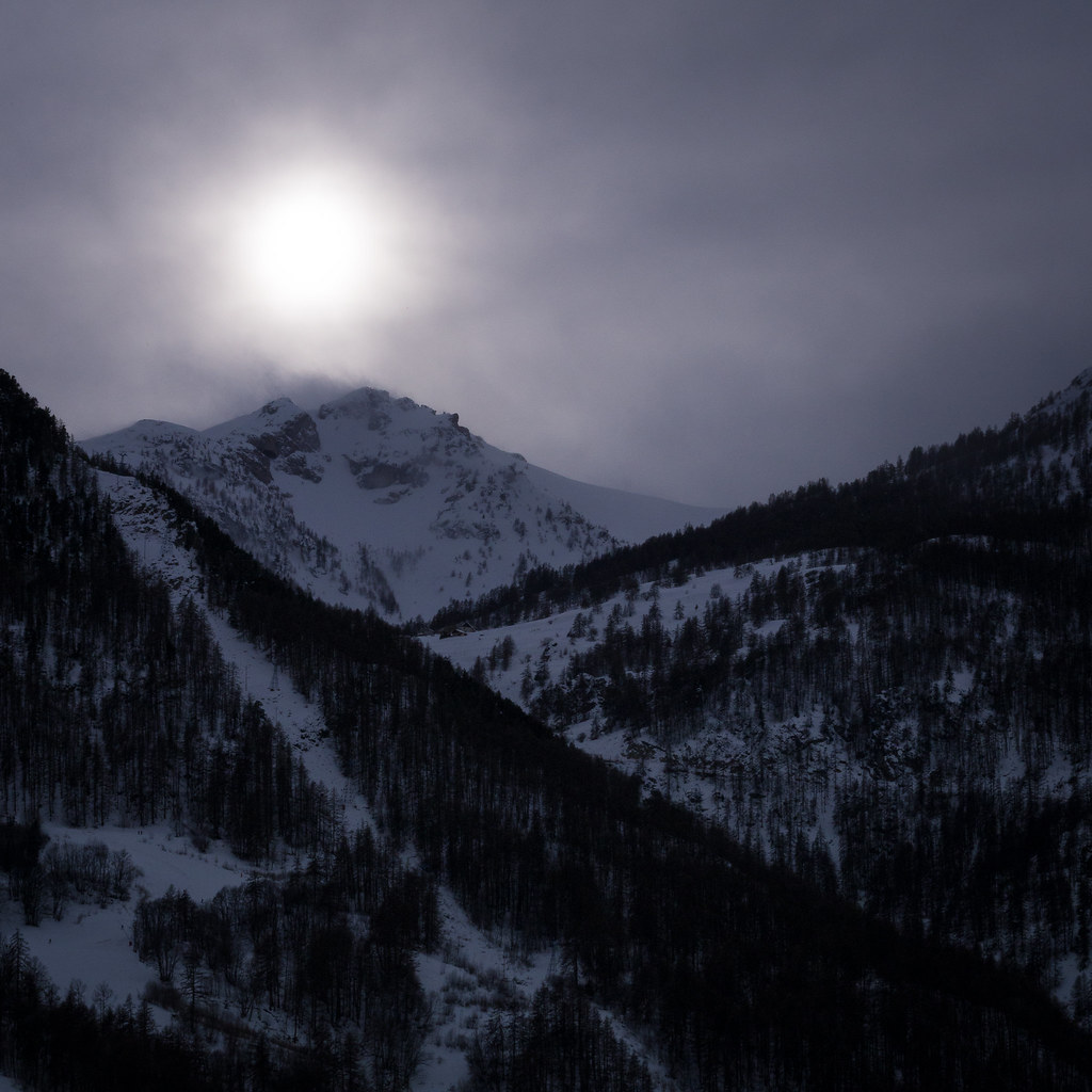 Iréel — Snow-Capped Peak Beneath a Veiled Sun