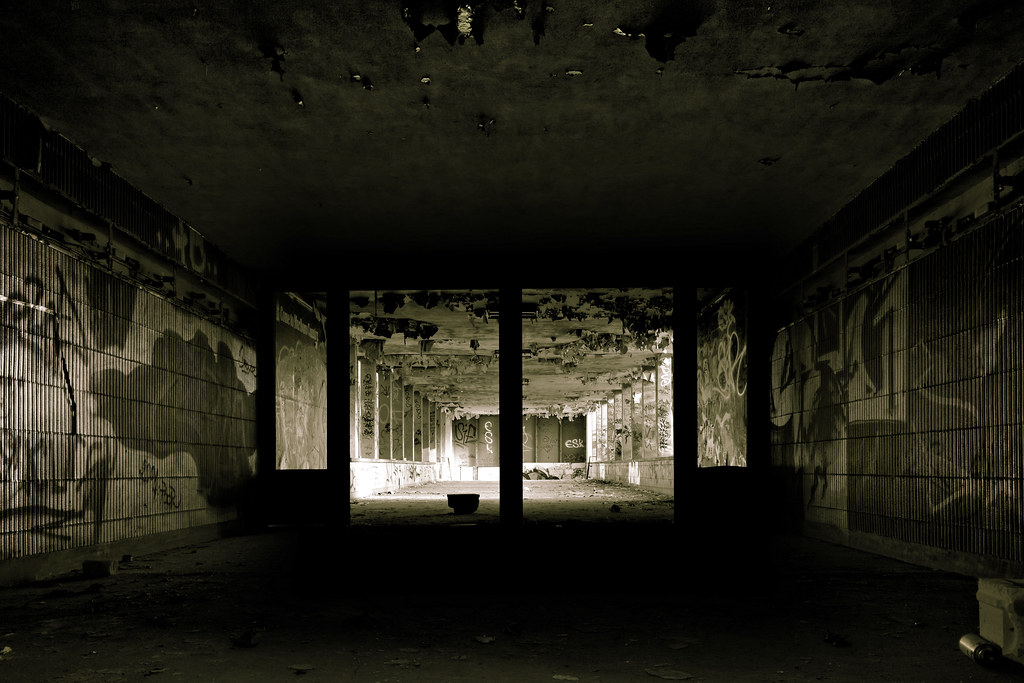 Abandoned underground corridor: graffiti, columns, and fading light