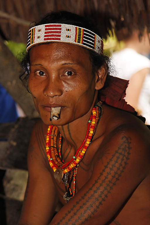 Mentawai portrait: Woman in traditional beadwork, headband, and clay pipe