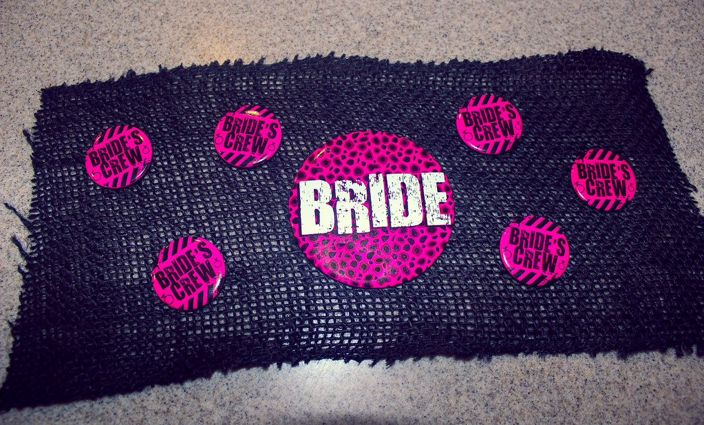Megan Korb's Bachelorette: Central 'BRIDE' Badge with Leopard Print, Surrounded by BRIDE'S CREW Pins on Black Burlap