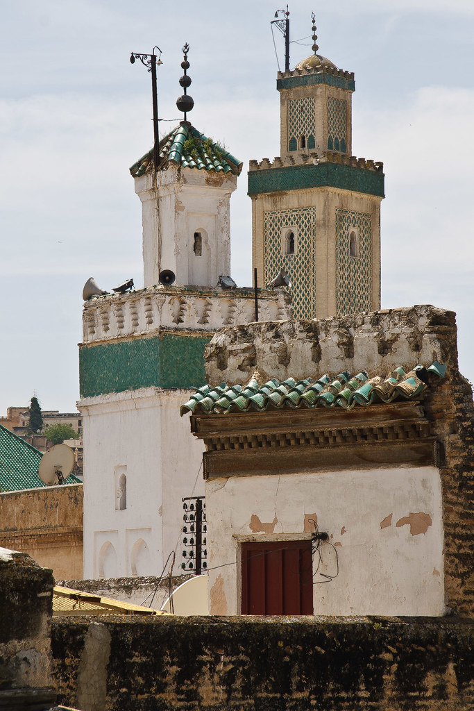 Rooftop View of a Moroccan Mosque: Green-Tiled Minaret and Whitewashed Facades