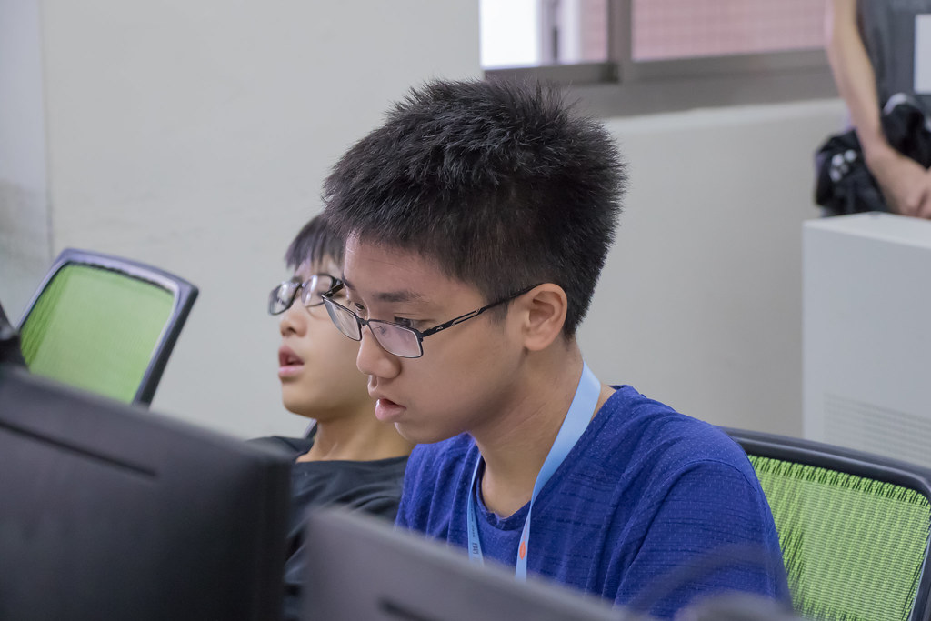 家維-6724: Focused student in a computer-lab workshop, monitoring screens during a collaborative session