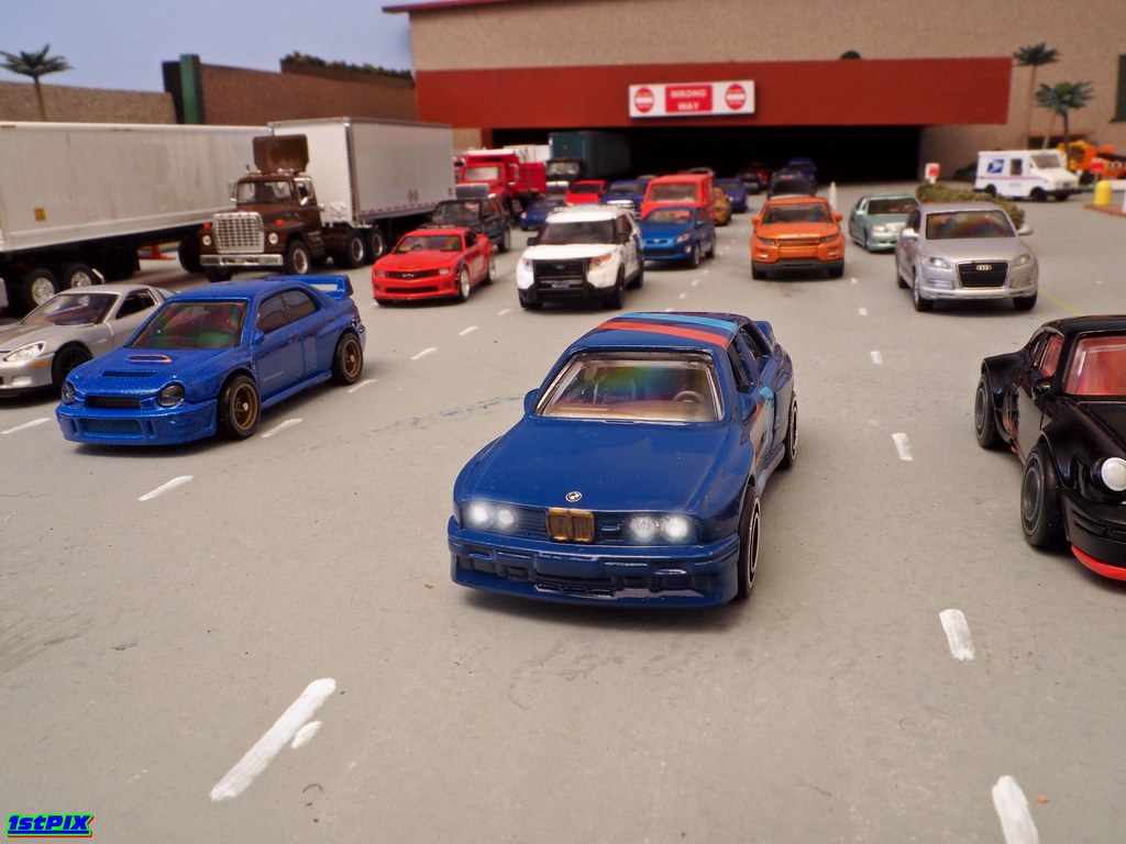 Blue BMW M3 Leads a 1:64-Scale Die-Cast Car Parade Through a Miniature City Diorama