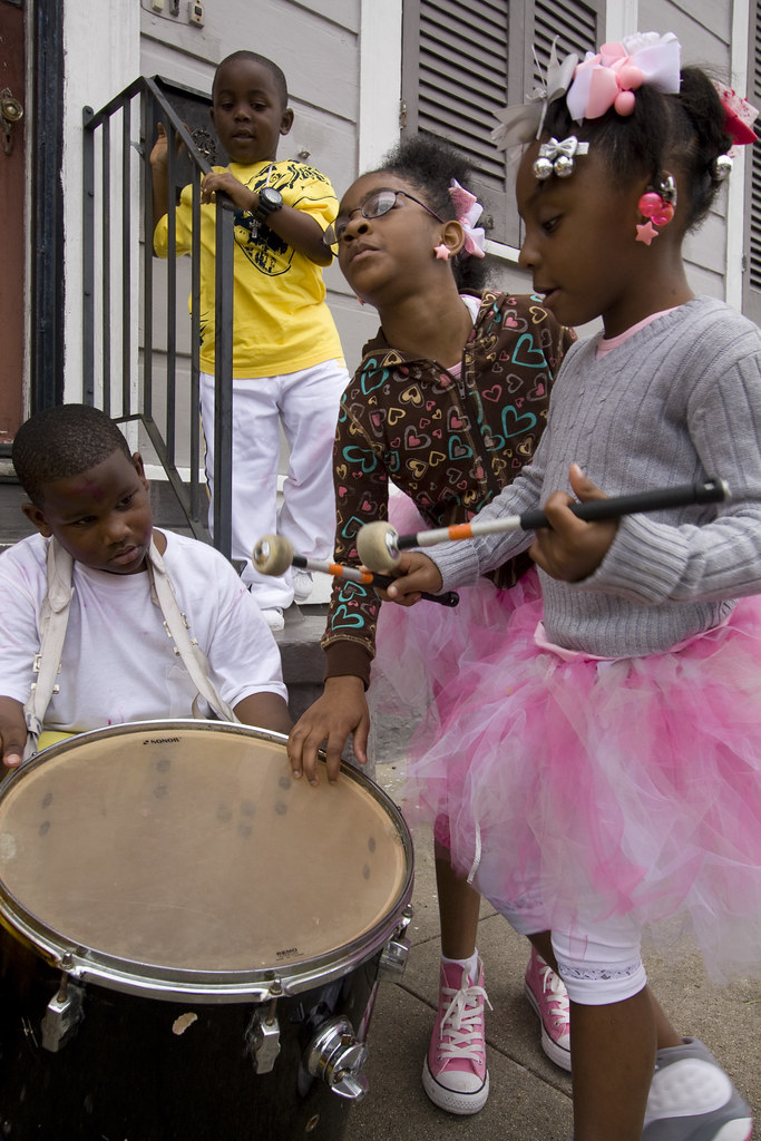 Urban Porch Percussion: Children Playing Drums and Mallets on a Residential Staircase
