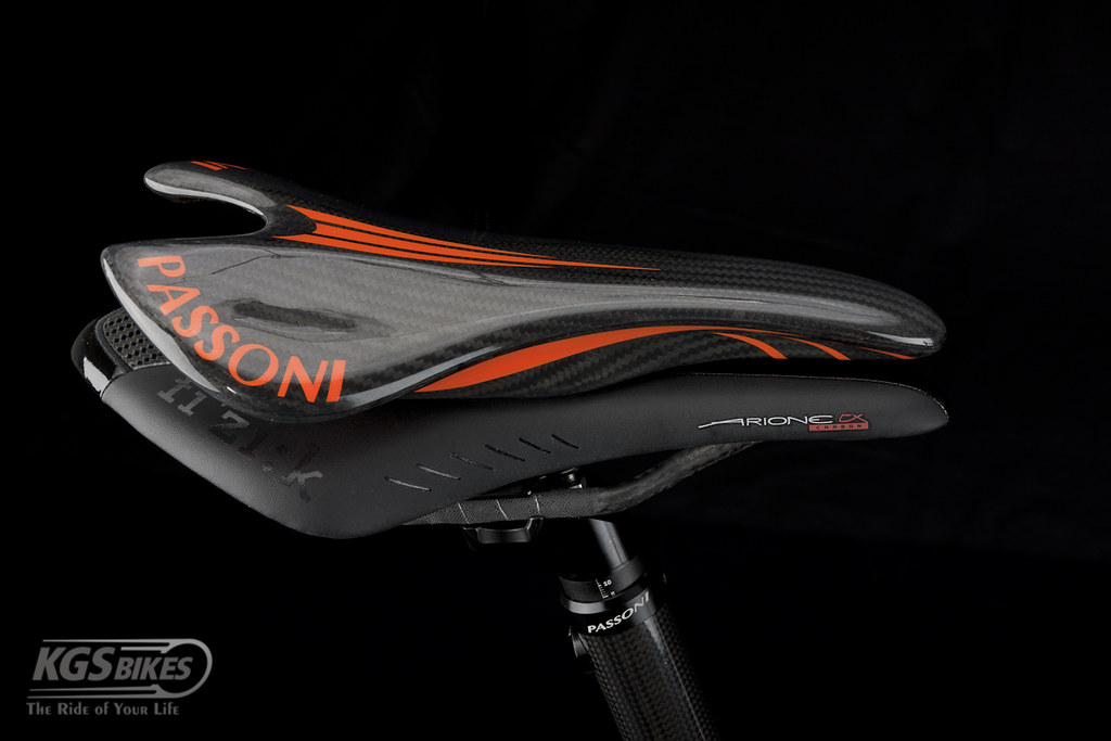 Passoni Carbon Saddle with Orange Branding, Mounted on a Carbon Seatpost — Studio Close-Up