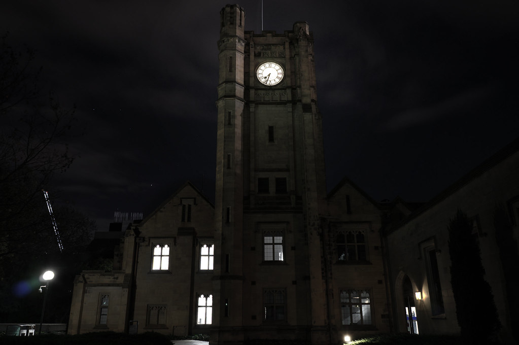 Night-time view of the University of Melbourne Clock Tower and Gothic Revival campus buildings