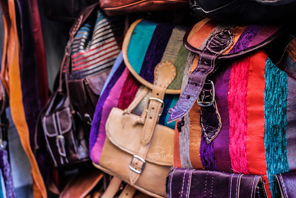 Granada Market Textures: Striped Fabrics and Leather Bags in Vivid Color