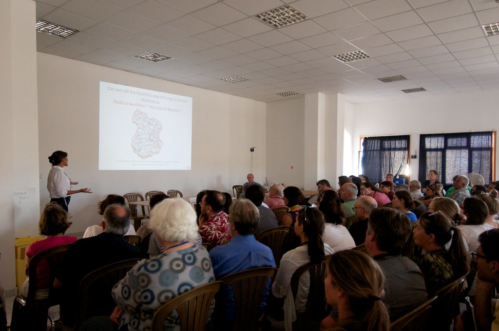 Templeton Conference: Speaker at lectern addresses a crowded room with a projected map on the wall