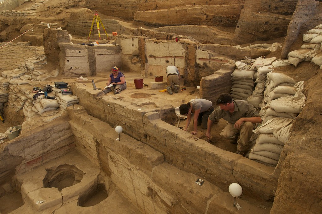 Building 80 Excavation: Archaeologists inspect a plaster-walled trench in a desert dig