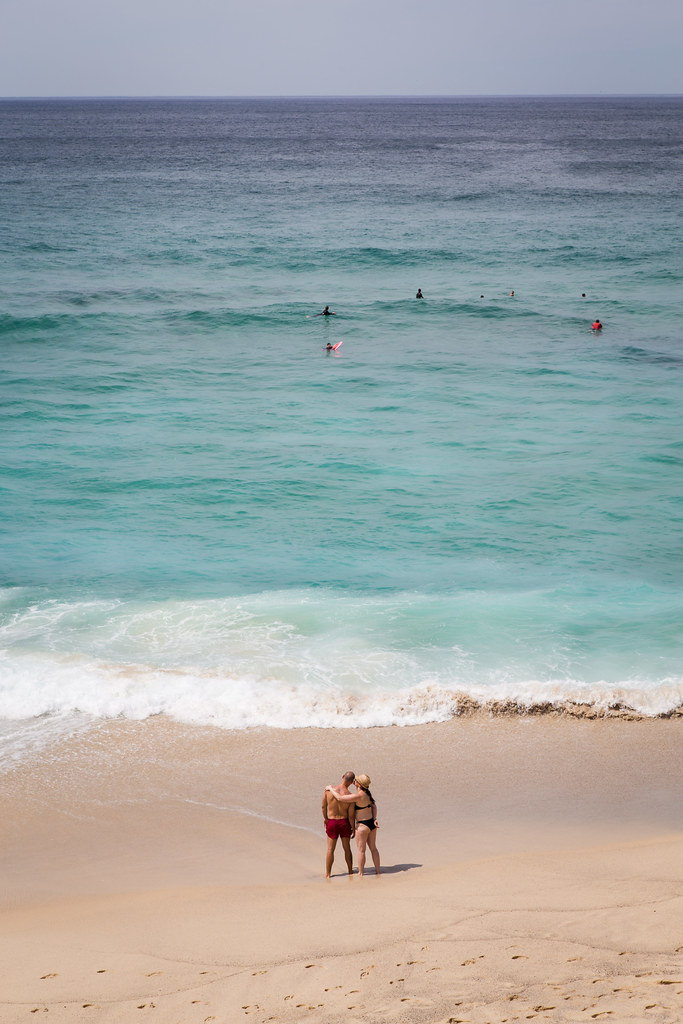 Bronte Beach, Sydney: Couple embraces at the water's edge as turquoise surf rolls onto pale sand