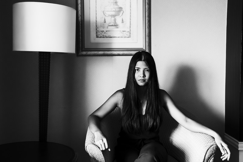 Monochrome Studio Portrait: Woman Seated in an Interior with Lamp and Framed Artwork