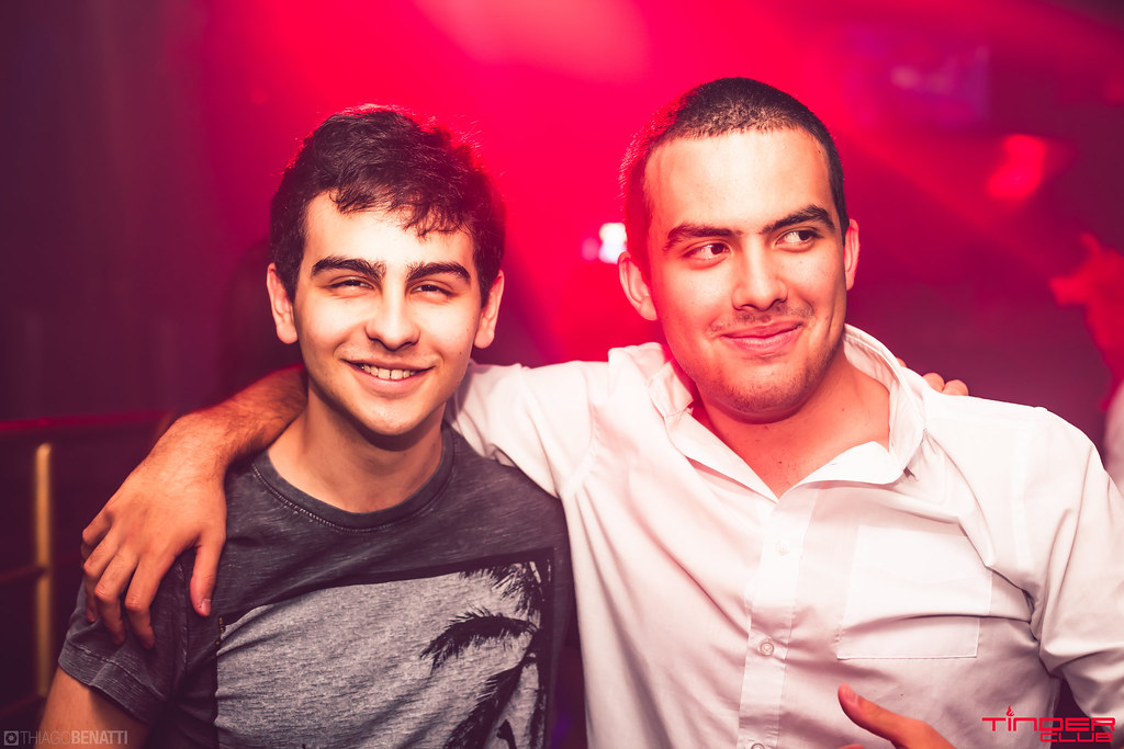 Two friends in a nightclub under crimson ambient lighting
