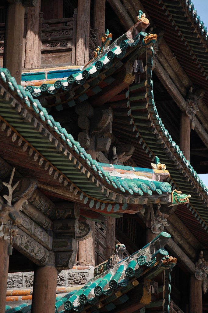 Ornate turquoise-glazed roof eaves and carved timber at Yungang Grottoes, Datong, Shanxi