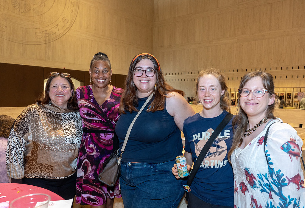 Educator Appreciation Night at the LBJ Library: Five attendees pose in the exhibition hall during a reception, May 8, 2024.