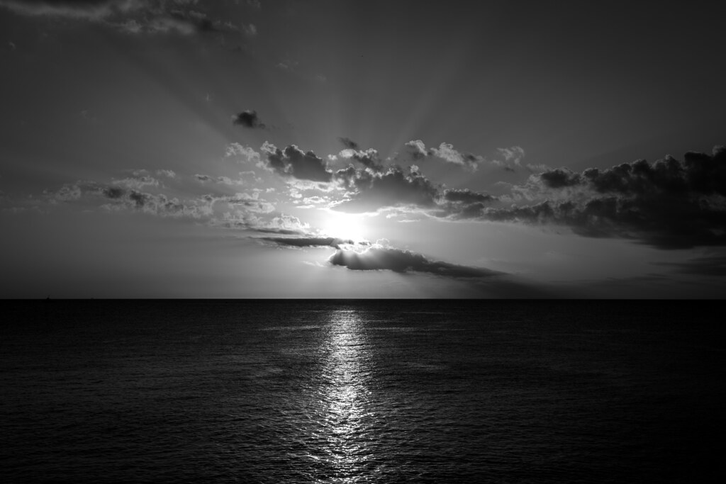 Dawn over Sicily: sunburst breaking through clouds over the Tyrrhenian Sea (Monochrome)