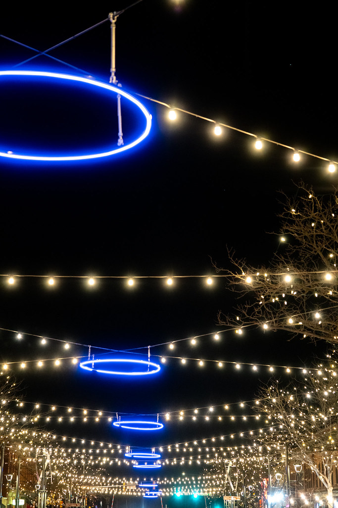 Blue Neon Circles Over a Festive Downtown Fort Collins Street at Night