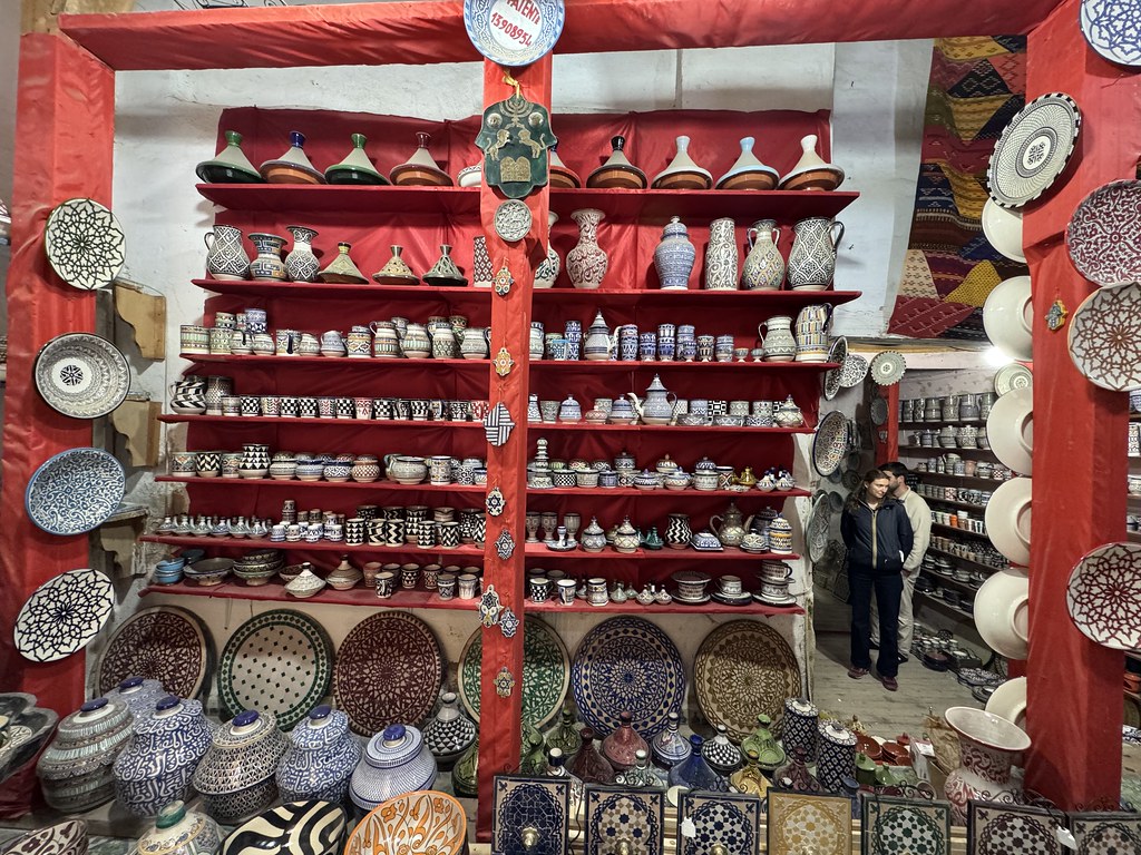 Colorful Moroccan Ceramic Shopfront in Fes: Red-Framed Shelves Overflowing with Pots and Plates
