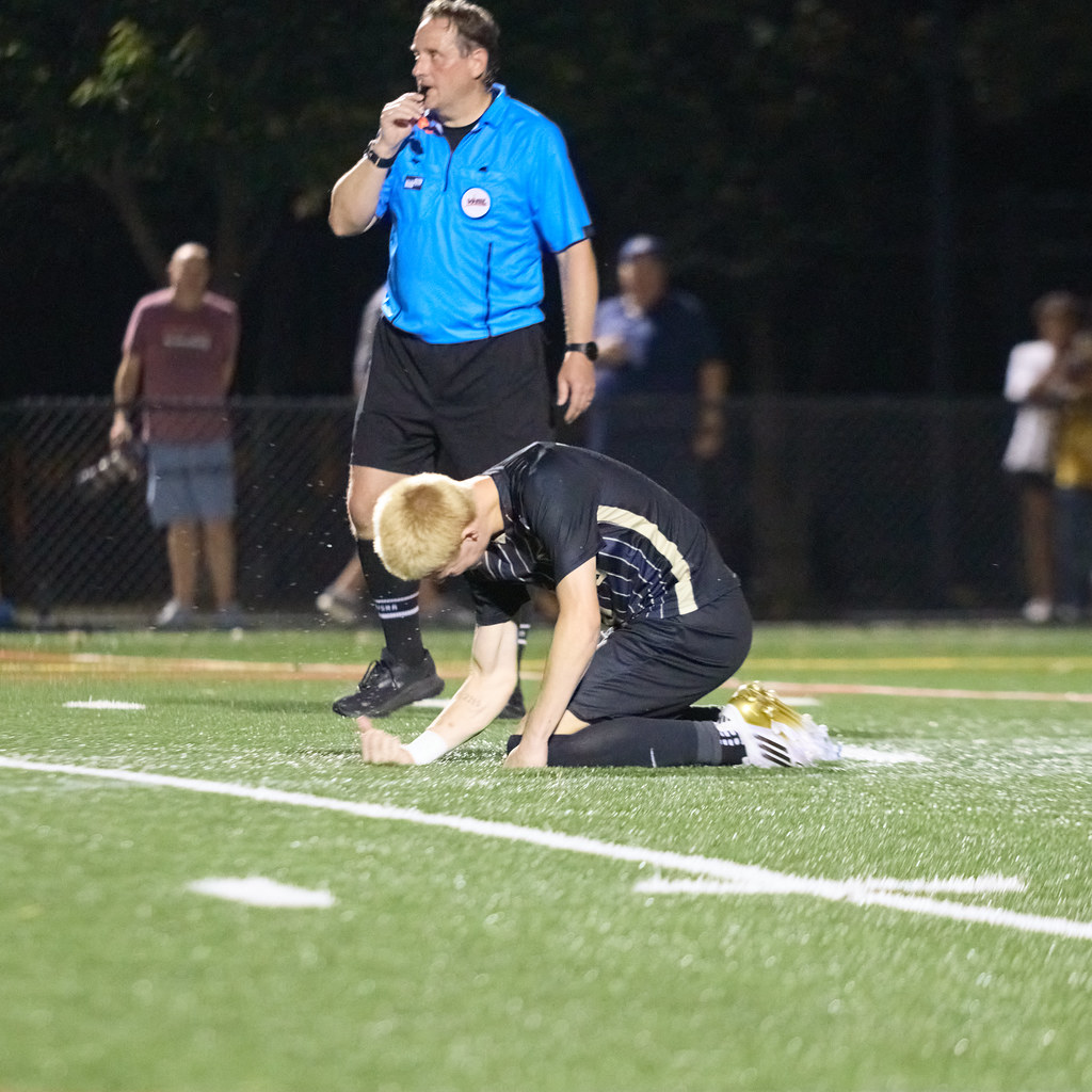 Regional 3A Semifinal: Lafayette v Tabb — referee with whistle watches over a kneeling player on illuminated turf