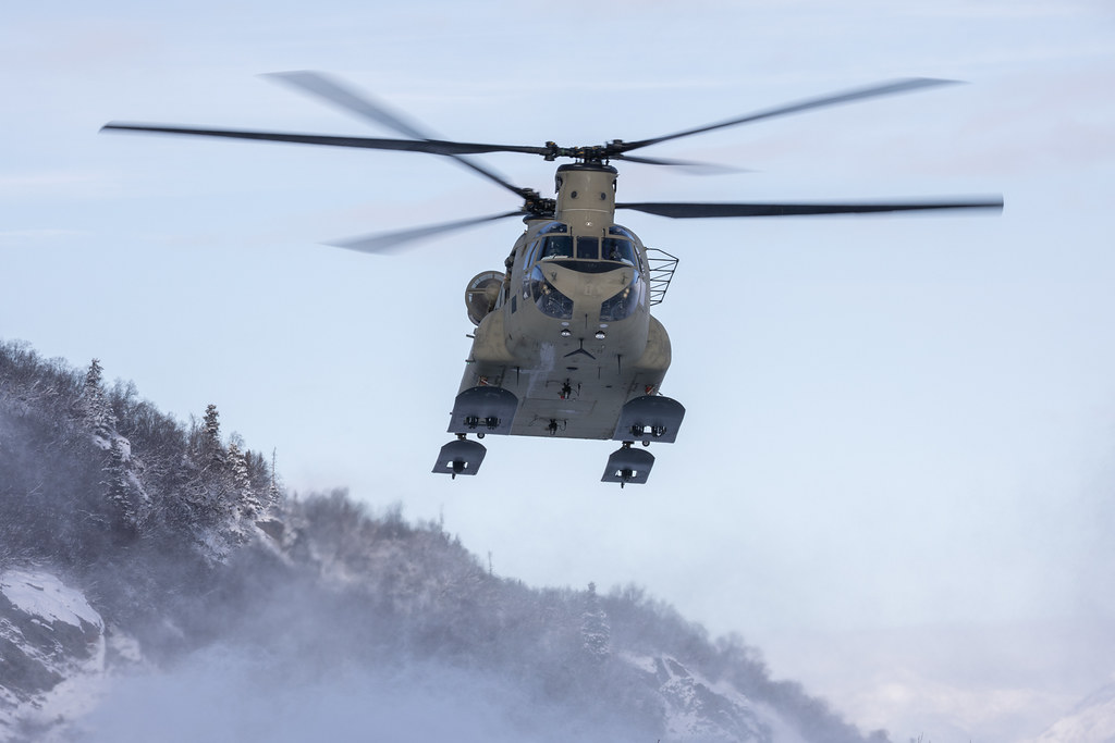 Alaska Army National Guard CH-47 Chinook in low pass over snow-covered terrain near Knik Glacier, Southcentral Alaska