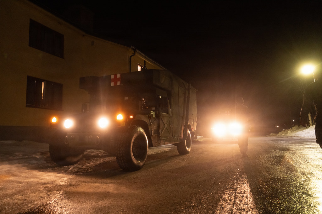 Nighttime Arctic Drill: U.S. Navy hospital corpsman guides armored M997A3 ambulance during en-route casualty care training in Setermoen, Norway (Cold Response 26)