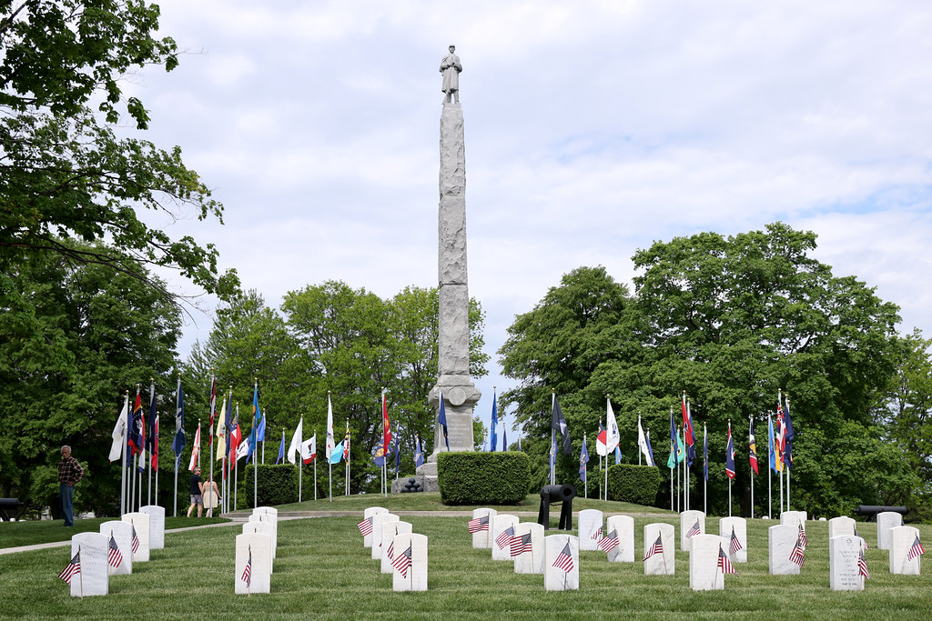 Memorial Day Observance at Wood National Cemetery: Obelisk Monument Surrounded by Flags and Neatly Arranged Headstones