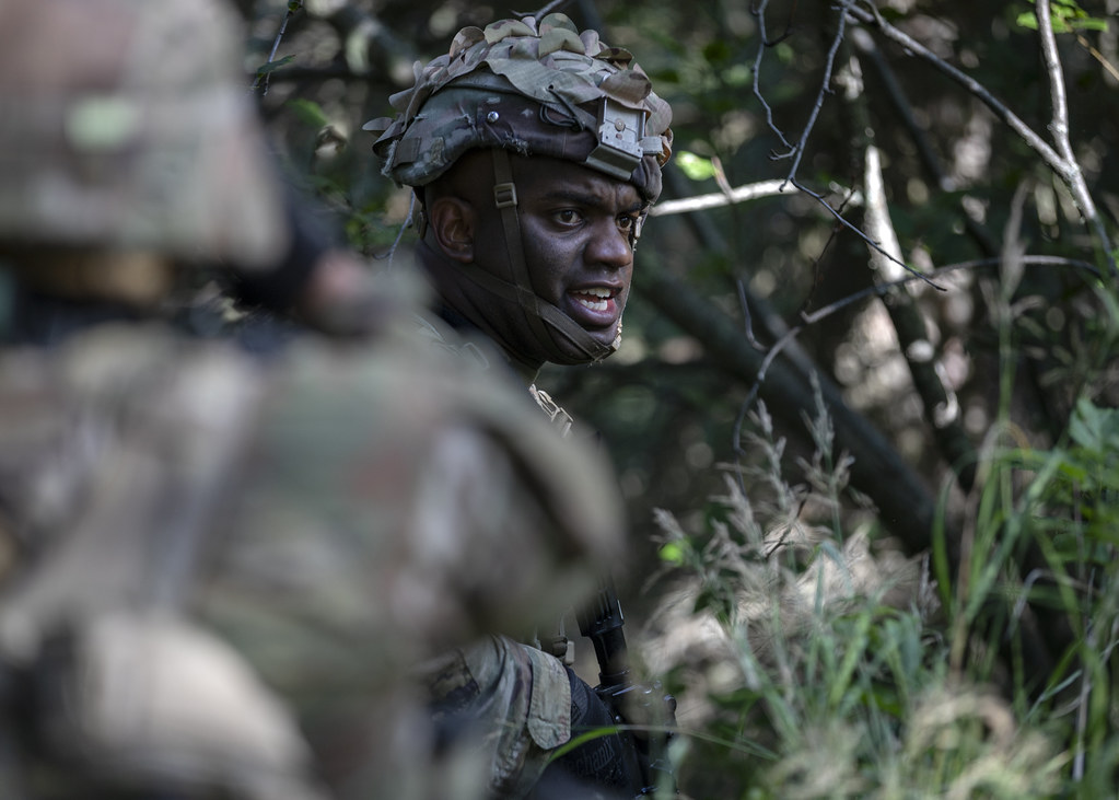 Infantry Advanced Leader Course field exercise: soldiers maneuver through dense vegetation