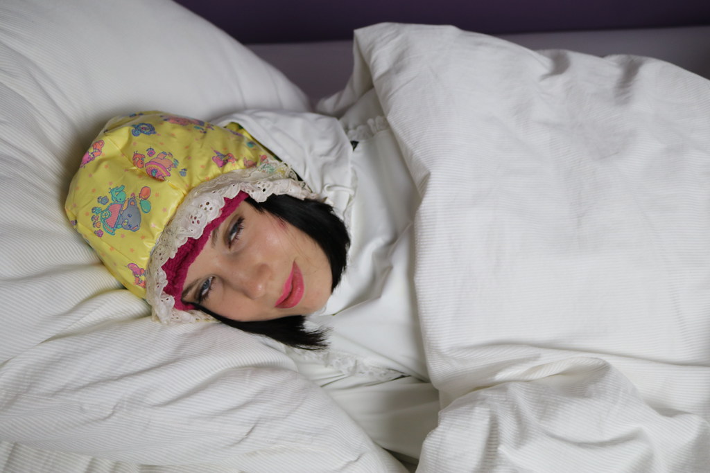 Resting in White Bedding: Portrait of a Woman in a Yellow Cartoon-Print Sleep Cap