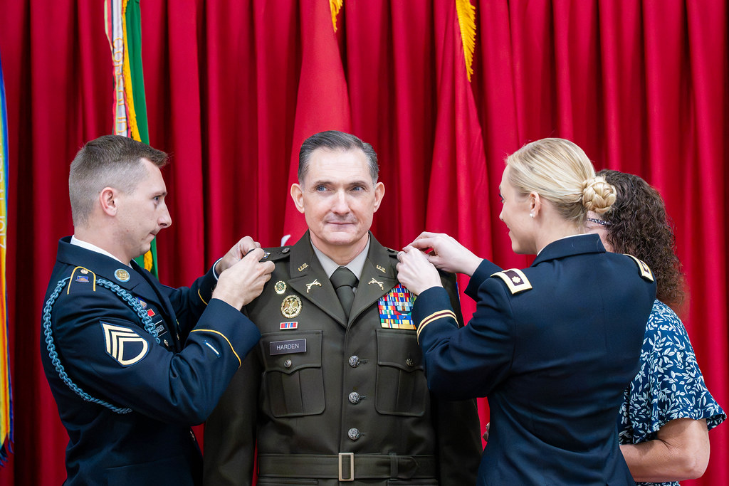 Colonel’s Promotion Ceremony: Attendants Adjust Insignia on Army Dress Uniform