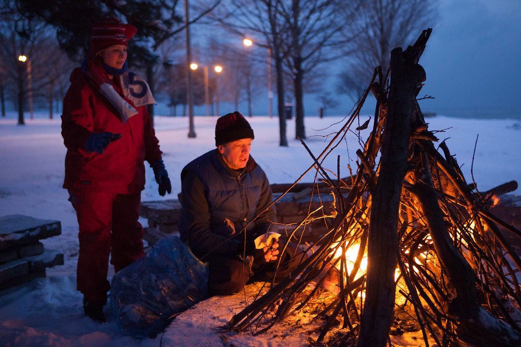 Keeping Warm by a Snow-Covered Campfire at Blue Hour in the Park