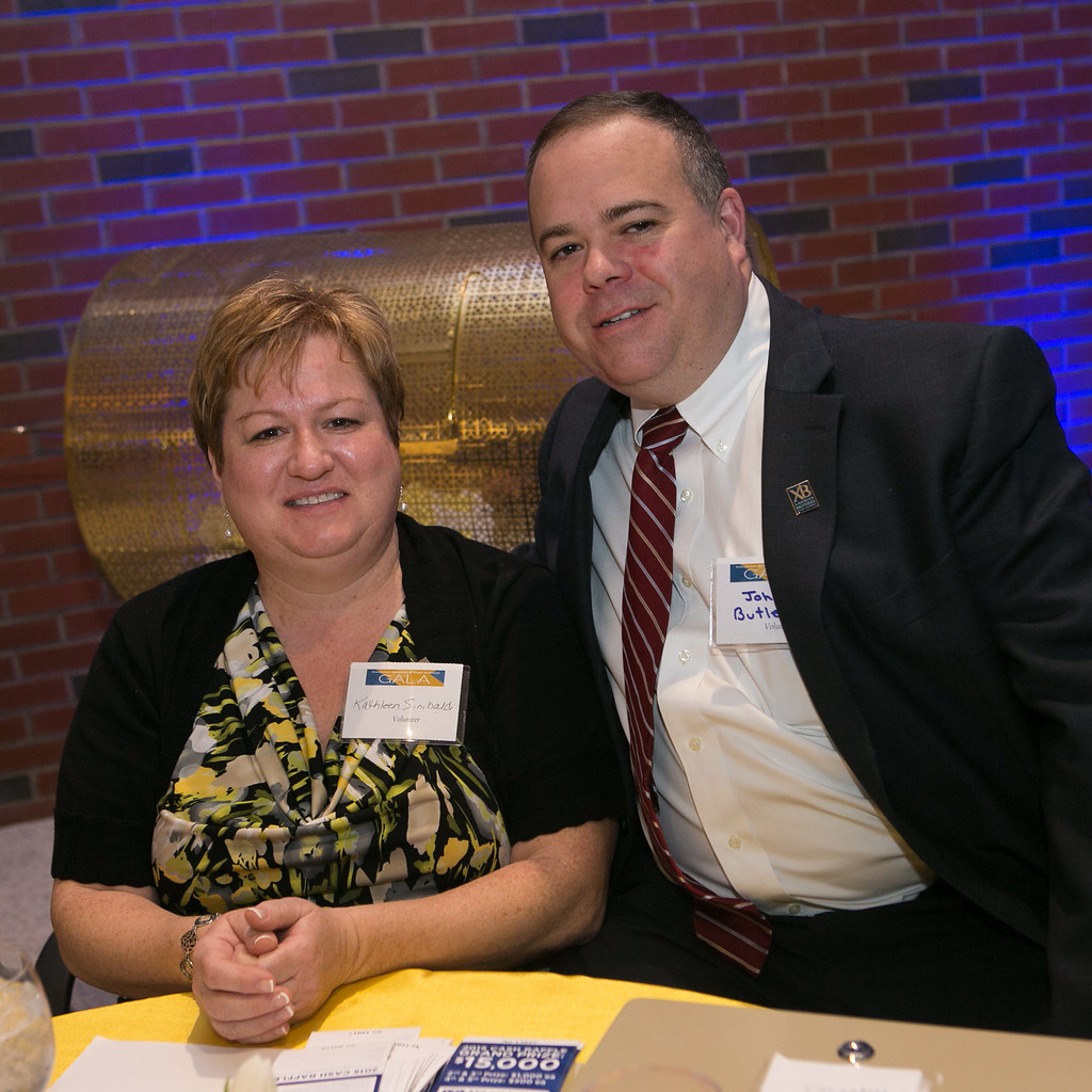 Portrait of Gala Volunteers at a Charity Reception, with a Brass Raffle Drum in the Background