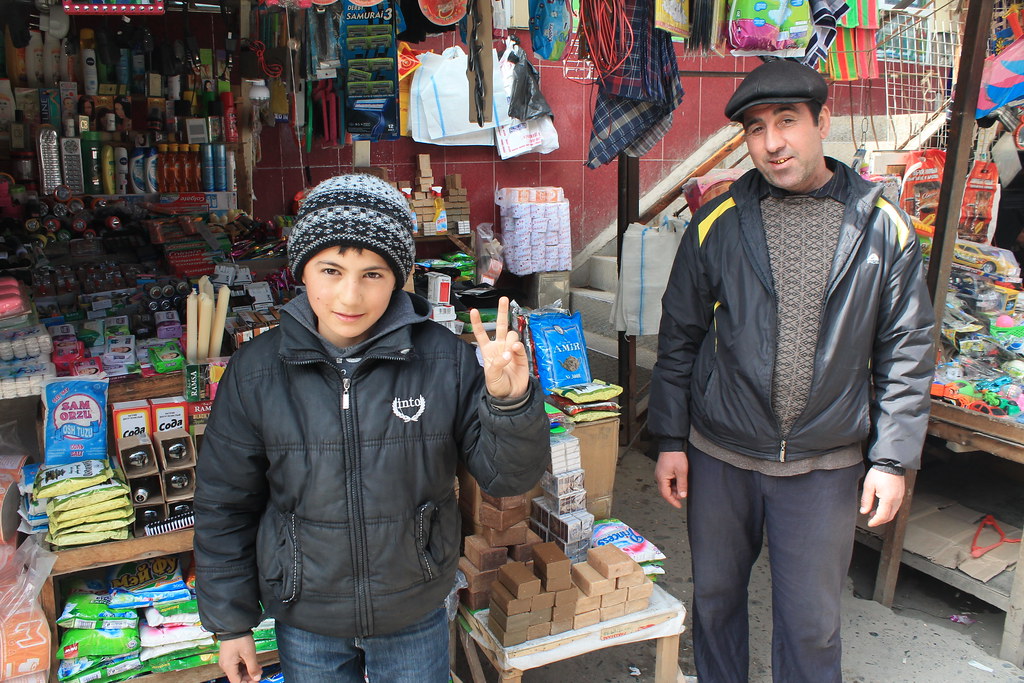 Busy Urgut Market: Two Vendors Pose Among Colorful Uzbek Goods