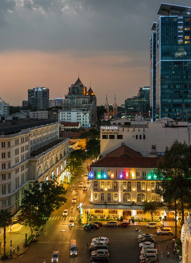 Twilight Over Ho Chi Minh City: Neon-lit Continental Saigon and Historic Street Scene from a Rooftop View