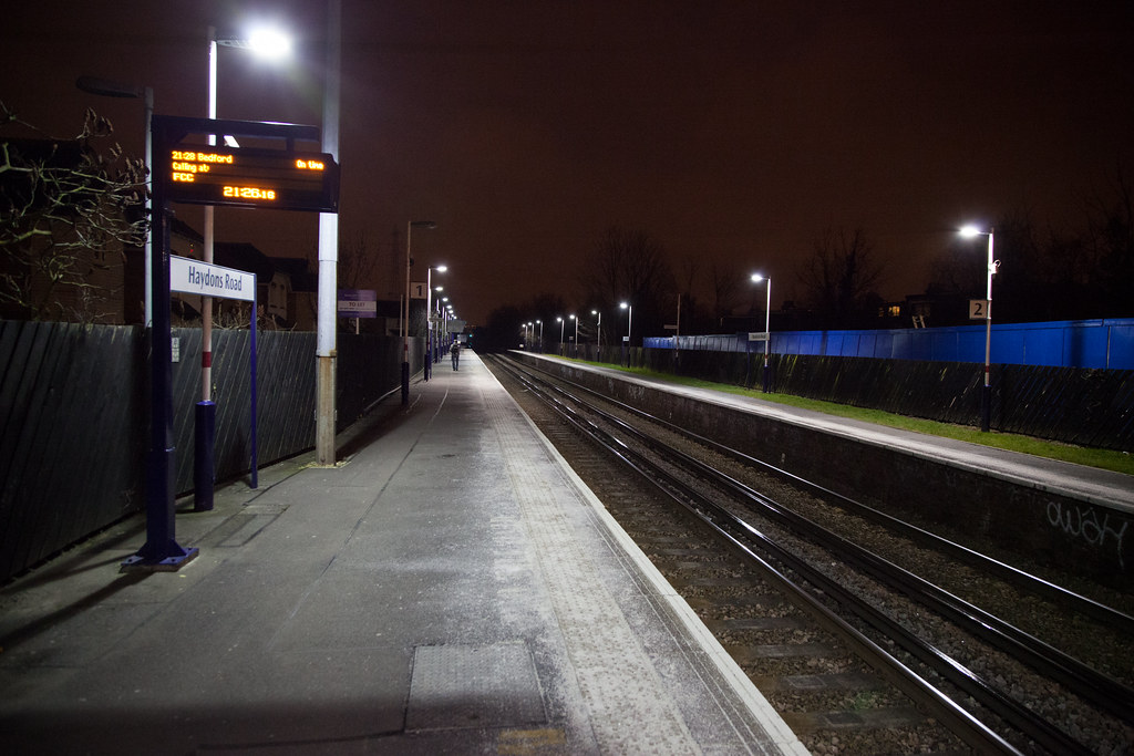 Haydons Road Station at Night: Quiet Platform with Illumined Tracks