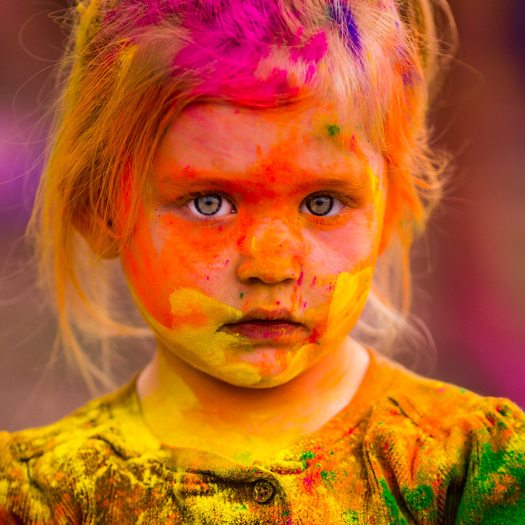 Powdered Innocence: A Close-Up Portrait of a Child Enveloped in Holi-Color