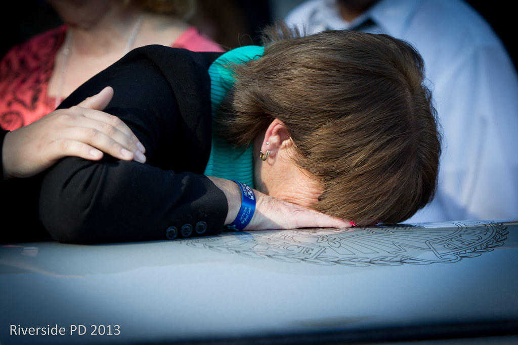 Memorial Moment: Riverside Police Department attendee bows head on a patrol vehicle during Officer Michael Crain's memorial at Riverside National Cemetery (2013)