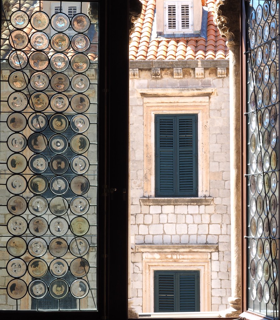 Dubrovnik Window Ensemble: Stone Facade with Blue Shutters Framed by Circular Glass Panels