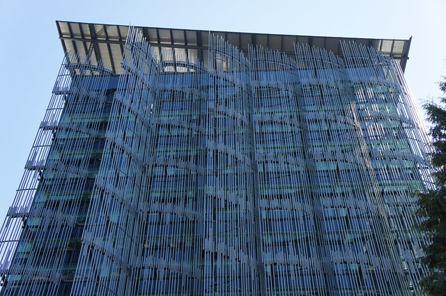 Low-angle view of Edith Green-Wendell Wyatt Federal Building in Portland with blue vertical louvers over glass, creating a ribbed façade against a clear sky.