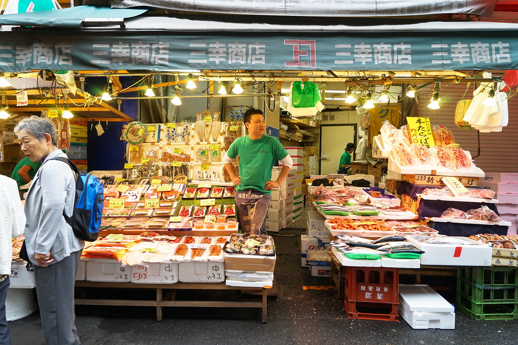 Japanese market stall selling dried seafood and fish under warm overhead lights