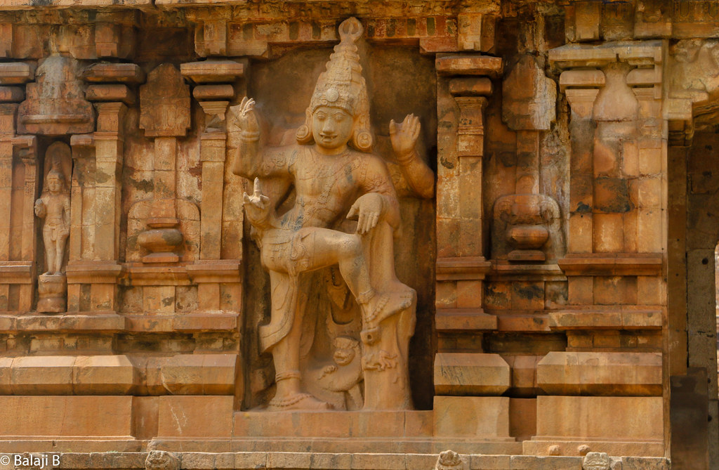 Deity sculpture in Brihadisvara Temple frieze, Thanjavur: sandstone relief amid Tamil temple architecture